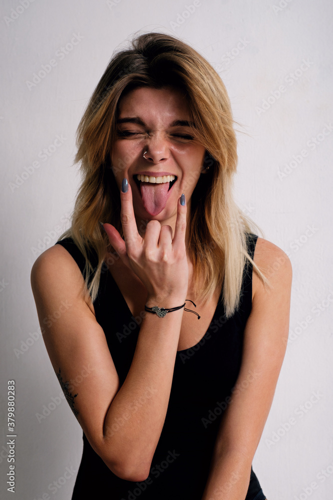 Young girl posing and showing rock sign Stock Photo | Adobe Stock