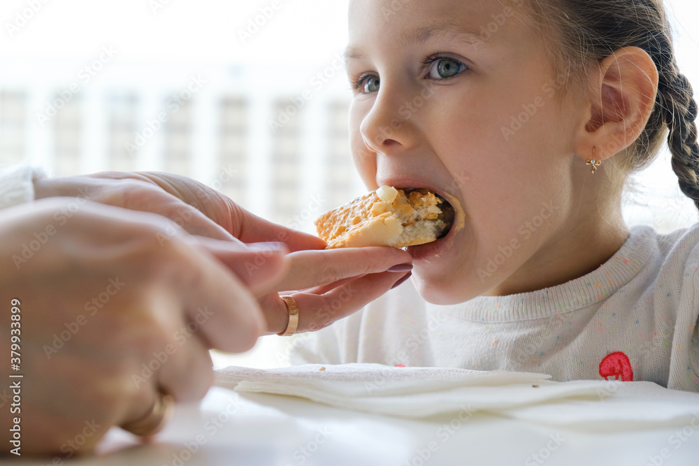 Little girl eating hamburger in a fast food restaurant. Child having ...