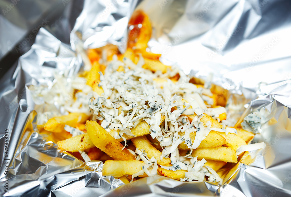 Gourmet French fries with melted gorgonzola cheese served in tin foil ...