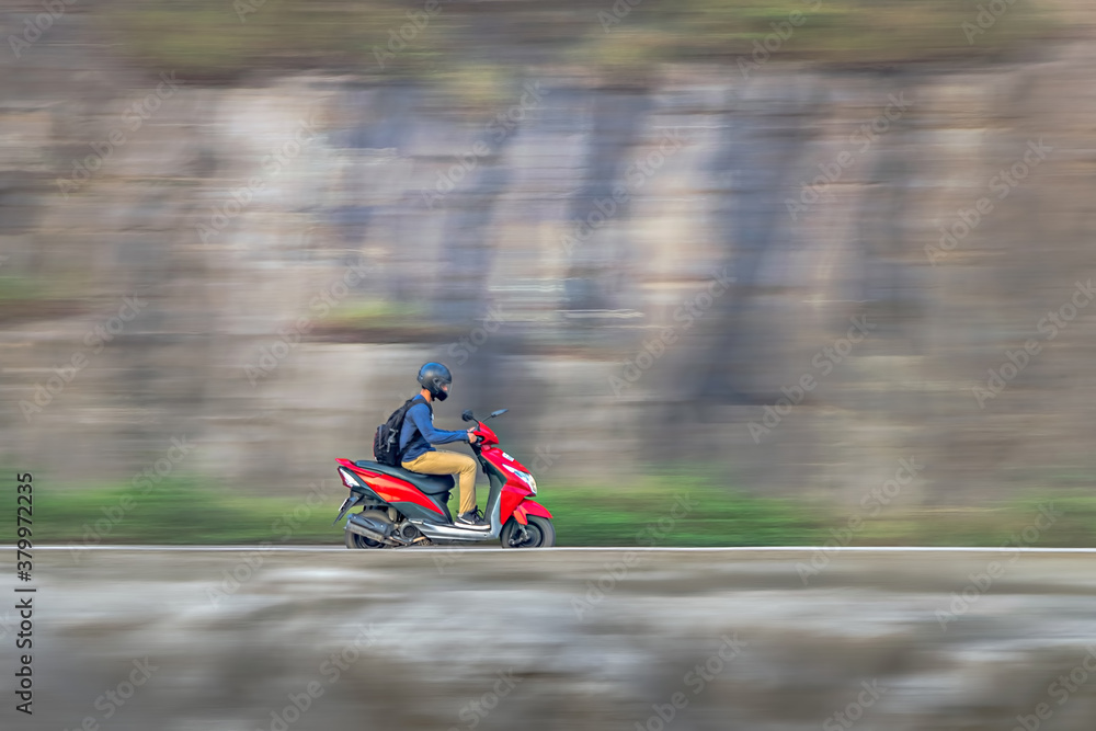 Motion blur image of a rider wearing helmet for safety, riding on two ...