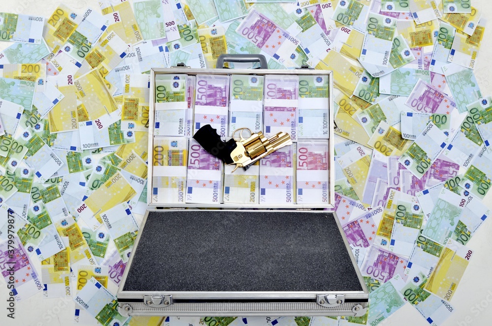 Criminal concept: Gold gun revolver and briefcase full of counterfeit ...