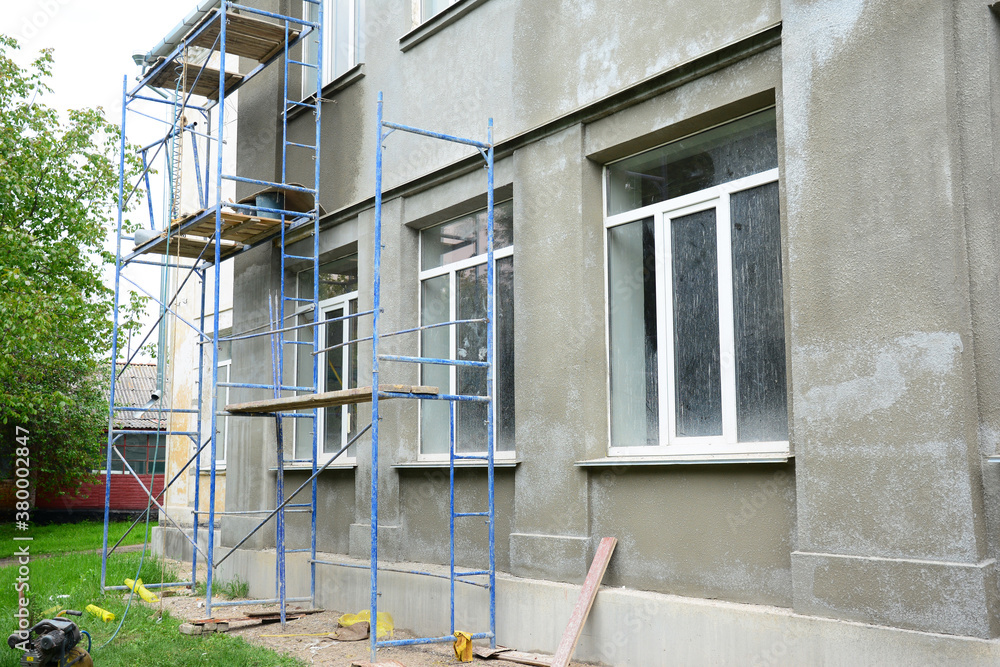 Renovating the facade of a building by applying stucco finish ...