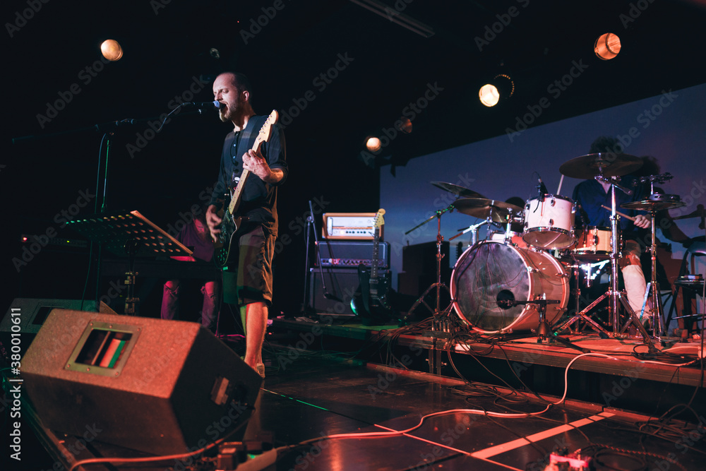 Lead singer singing and playing electric guitar on stage Stock Photo ...