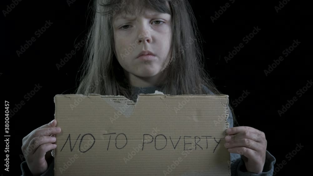 No poverty concept. Homeless little girl holding a sign no poverty on a black background. vídeo ...