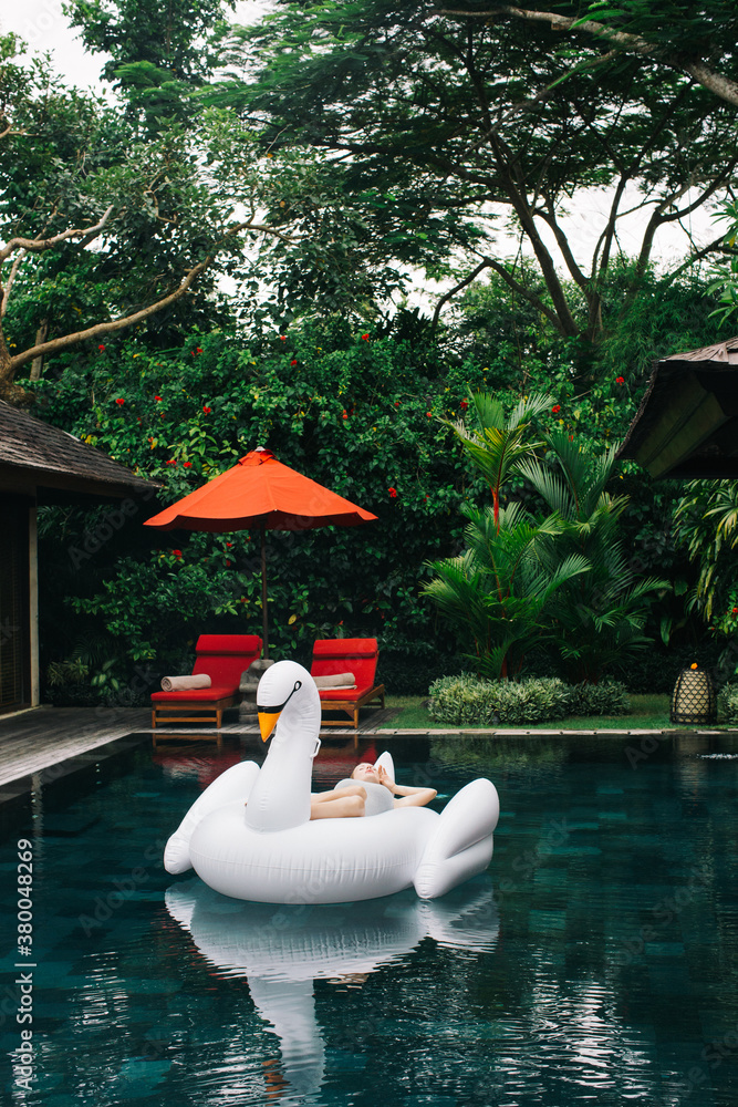 Pretty Woman Relaxing on Inflatable White Swan Pool Toy Stock Photo ...