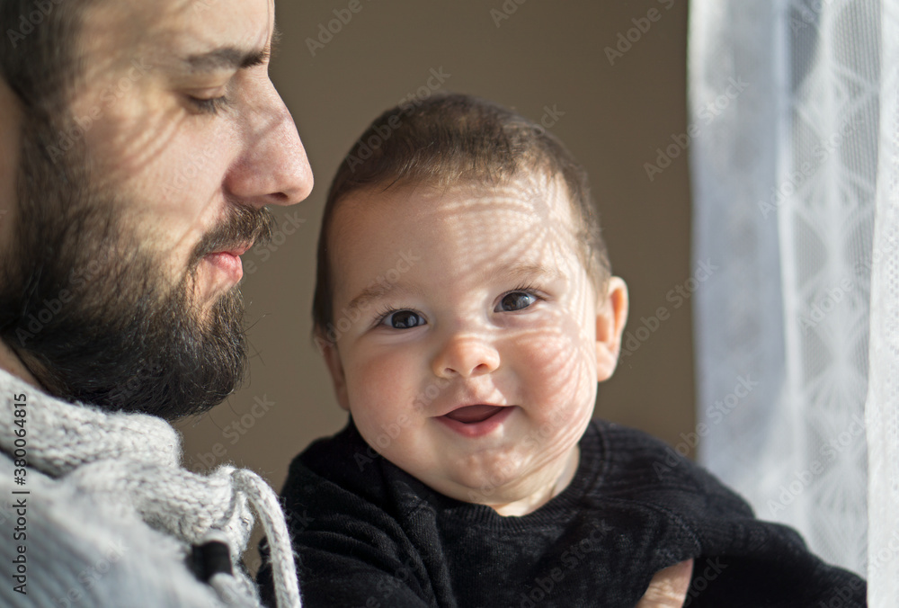 Baby with shadow on face in his father's arms Stock Photo | Adobe Stock