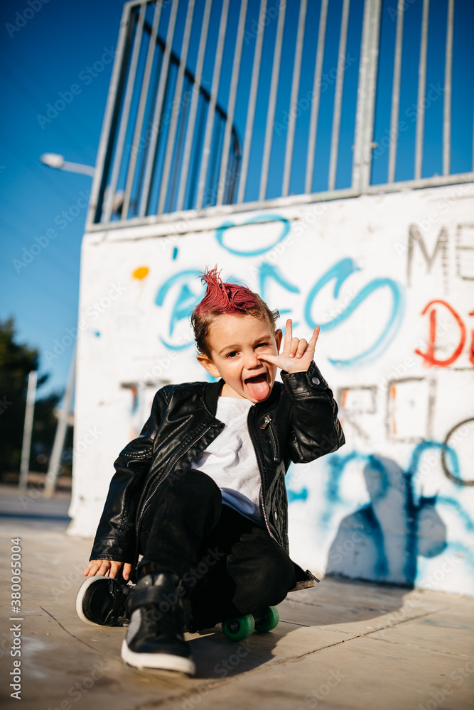 Cool kid with mohawk sticking out tongue and showing rock and roll sign ...