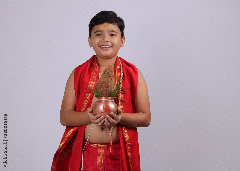 Foto de Young boy in Indian ethnic wear holding mangal kalash in hand ...