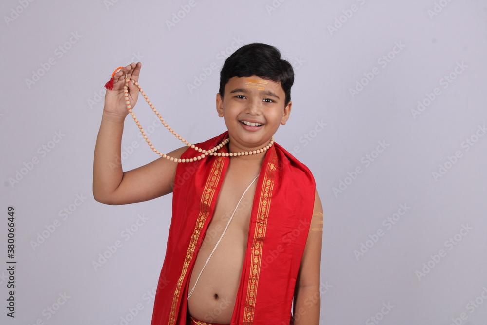 Indian boy in ethnic wear showing off his rosary or string of prayer ...