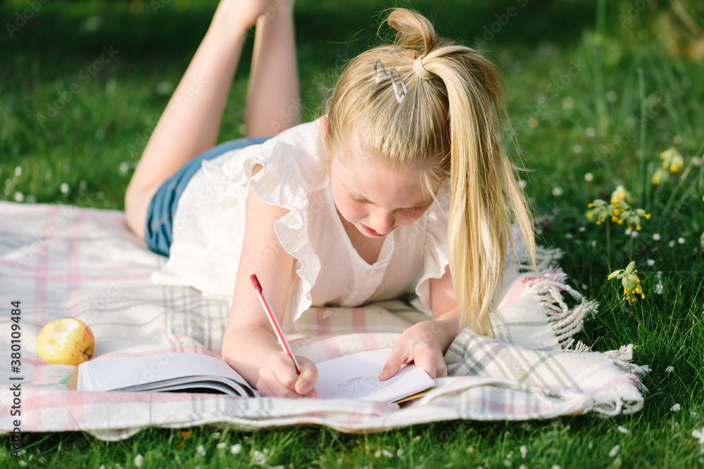 Tween girl drawing outdoors in early summer Stock Photo | Adobe Stock