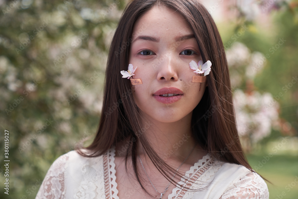 Portrait of a beautiful Asian woman in a white dress, she is standing ...