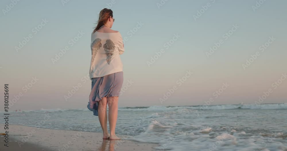 Cinematic slow motion woman on the beach contemplating the scenic ...
