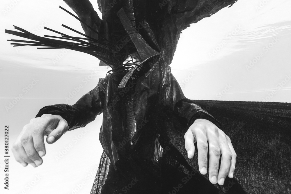 Beautiful man dressed in black floating in the pool Stock Photo | Adobe ...