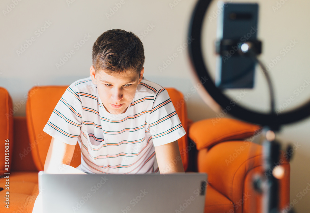 Young teenager blogger recording video at home. Cheerful cute boy ...