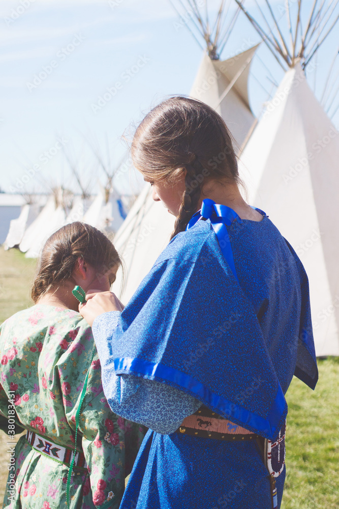 Native American sister fixes the braid of her younger sister Stock ...