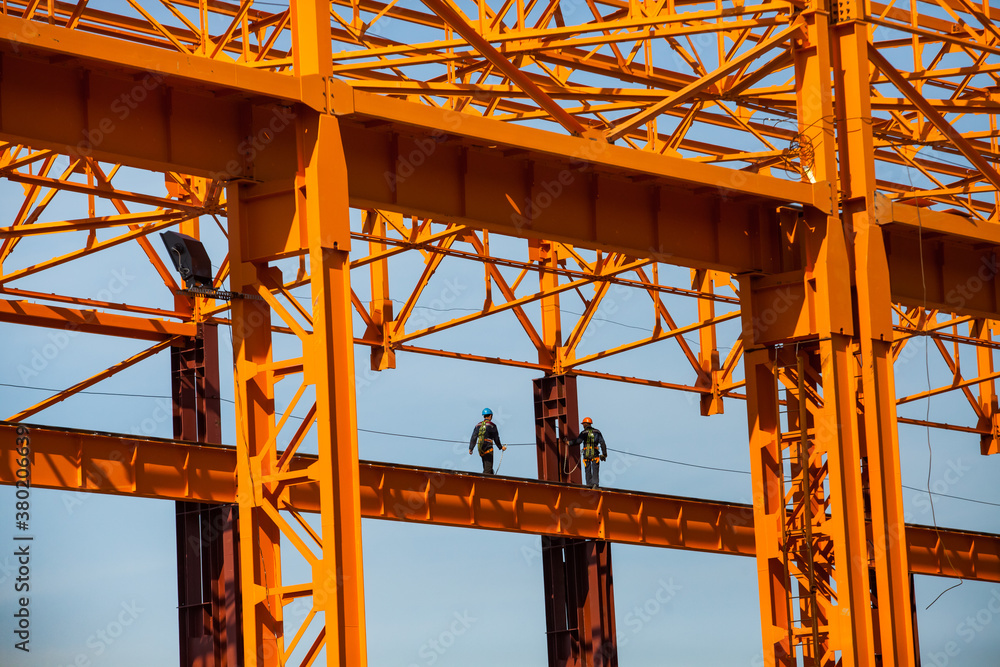 Construction of new industrial building. Assembling orange steel ...