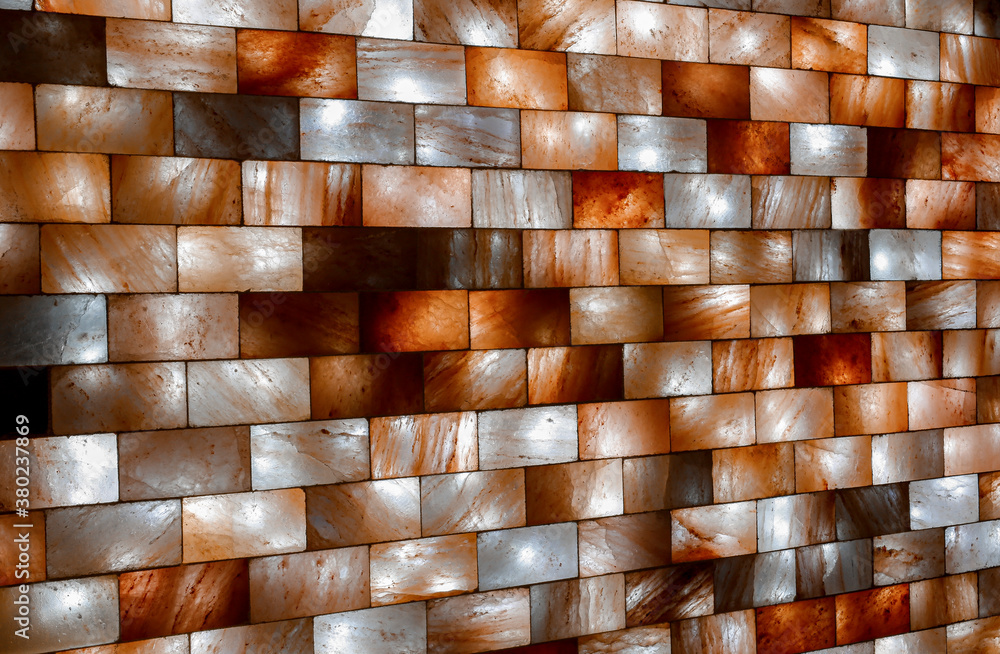 Wall of brick Himalayan salt as a background. Illuminated by LED lights ...
