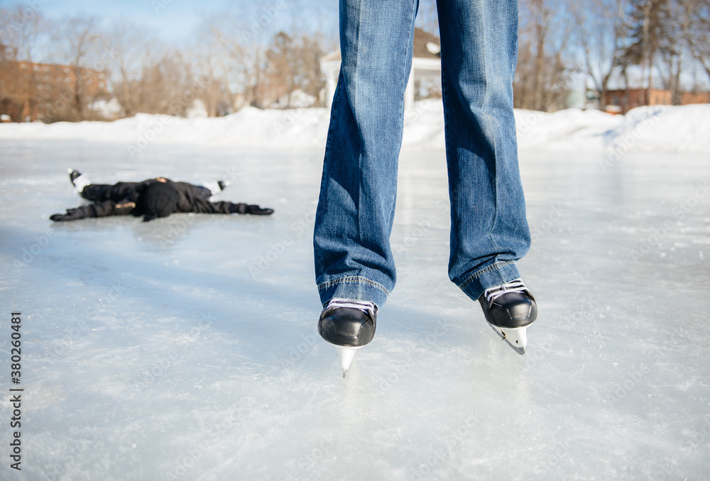 Child falls while his father teaches him how to ice skate Stock Photo ...