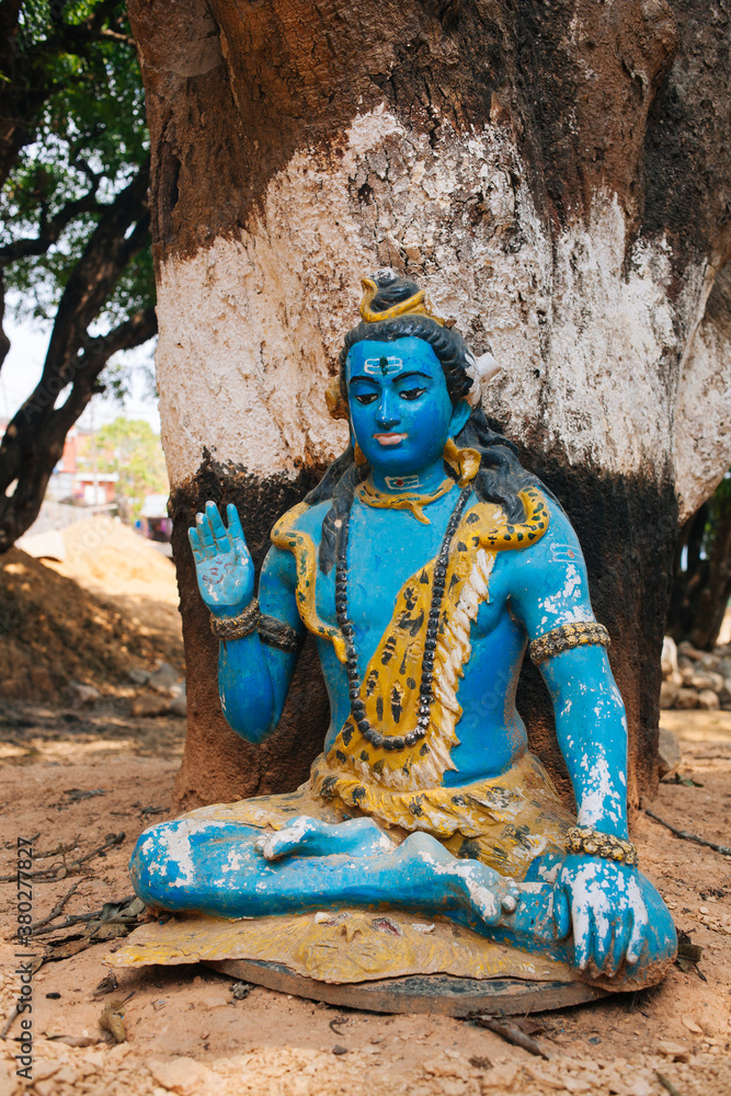 Statue of Lord Shiva underneath a tree. Stock Photo | Adobe Stock