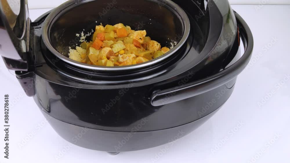 Macro Video of a multicooker. The man opens the pan and mixes the dish ...