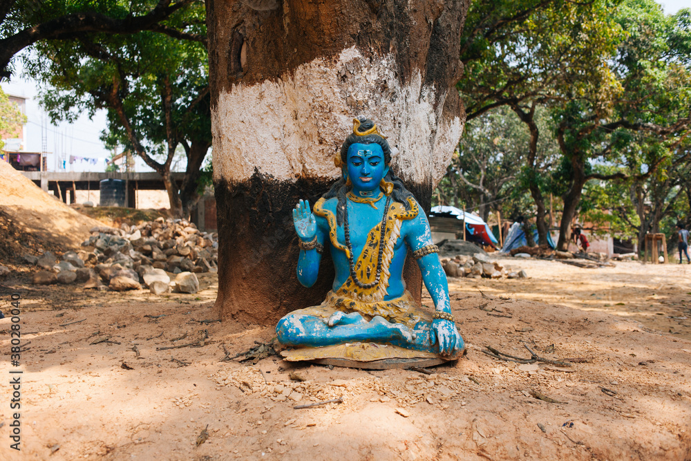 Statue of Lord Shiva underneath a tree. Stock Photo | Adobe Stock