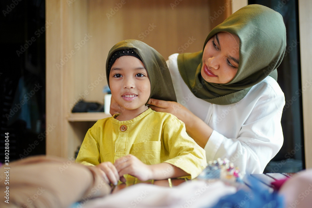 Muslim mother teaching her daughter how to wear a Hijab. Stock Photo ...