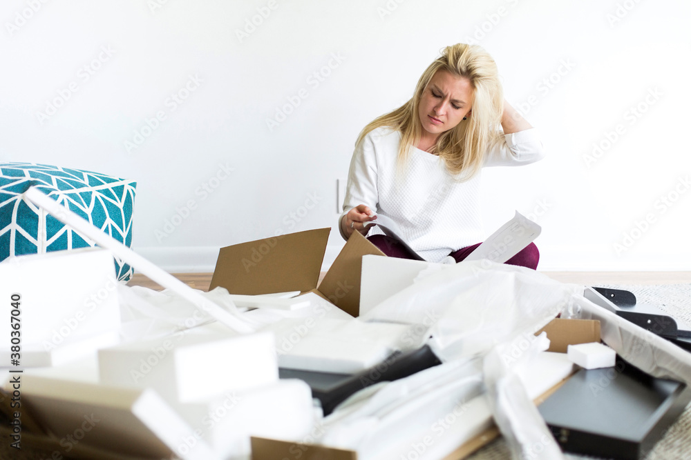 Confused woman reading instruction manual Stock Photo | Adobe Stock