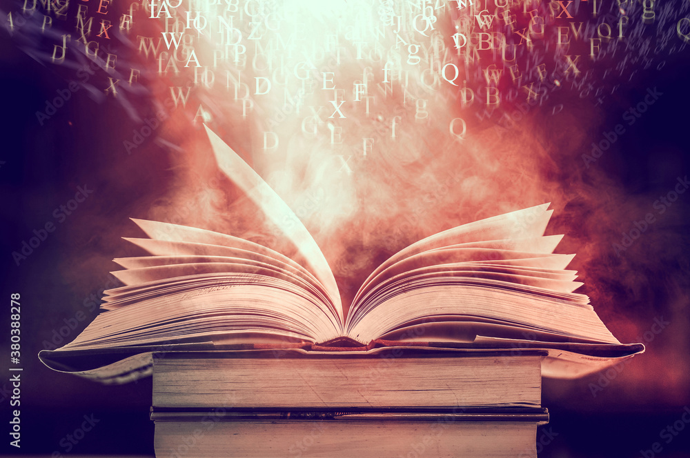 Open book on the table and english alphabet floating above the book in ...