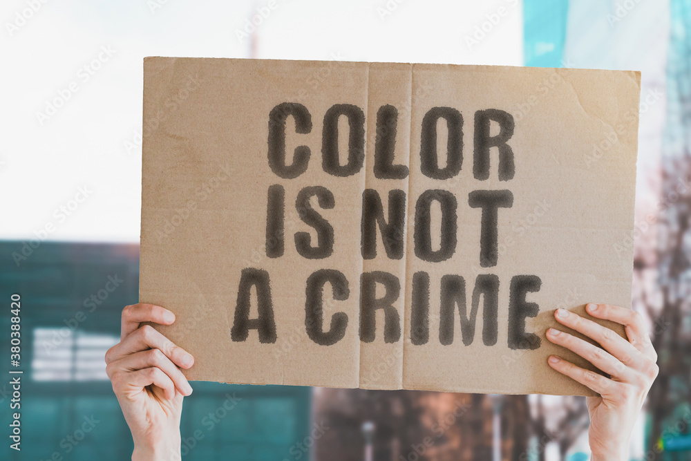 The question " Color is not a crime " on a banner in men's hand with ...