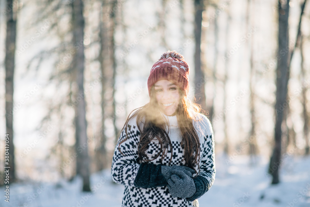 smiling teenage girl on a winter day so cold you can see her breath ...