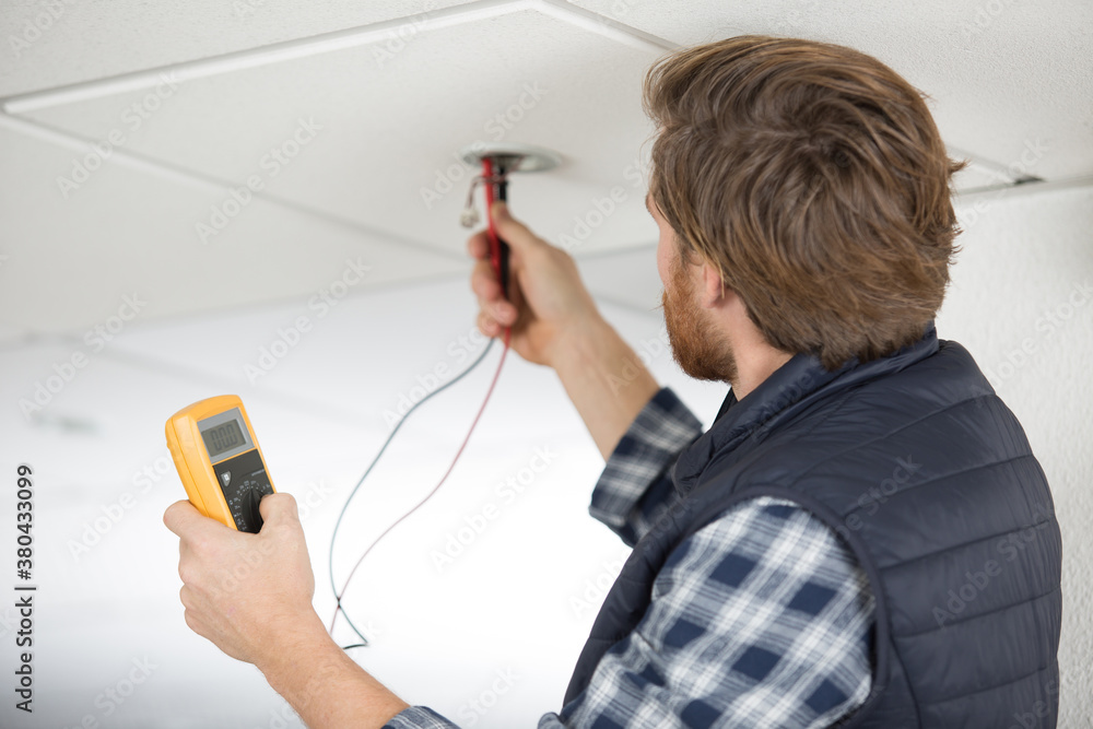 electrician using a multimeter to test spotlight connections Stock ...