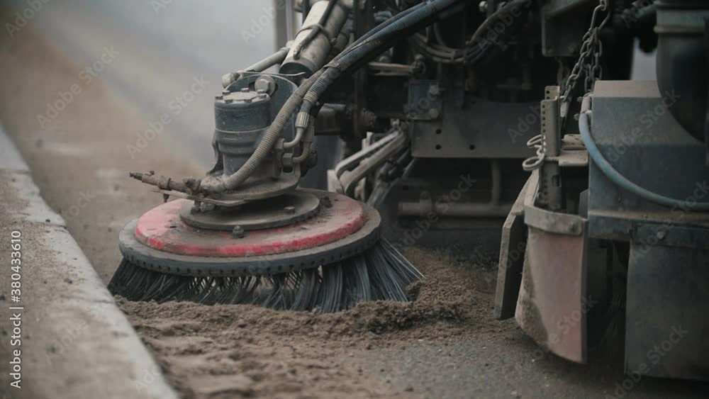 Industrial machine levels concrete dust with a sweeper on the side of ...