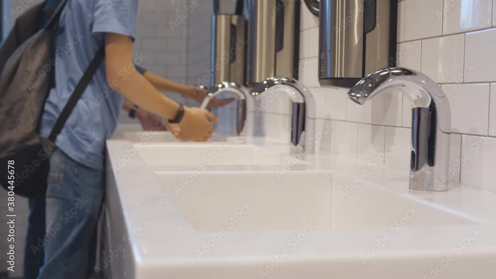 Diverse teen students mask washing hands in school toilet before lunch ...