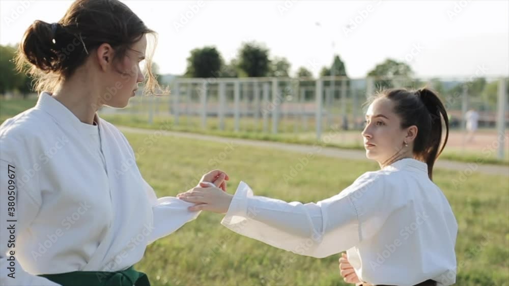 Outdoor karate training. A young girl conducts a technique in martial ...
