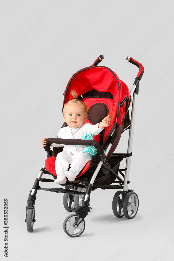 Cute little baby in stroller on light background Stock Photo | Adobe Stock