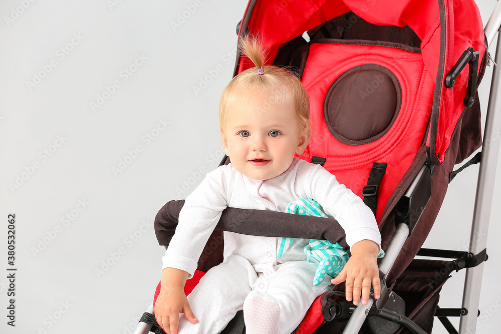 Cute little baby in stroller on light background Stock Photo | Adobe Stock