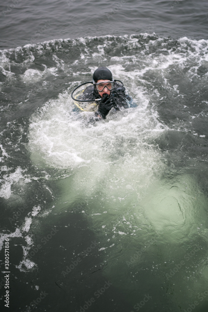 Scuba diver plunging into cold water Stock Photo | Adobe Stock