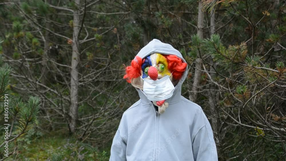 Boy on his back with a hooded jacket in the forest who, when he turns ...