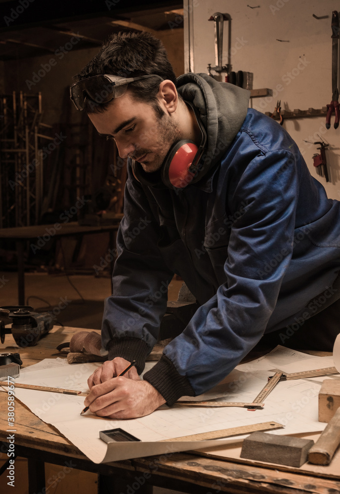 Young worker /engineer / drawing plans for new project in workshop ...