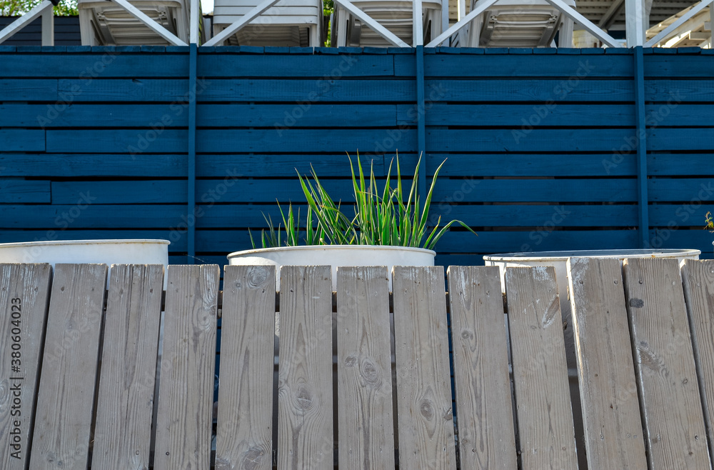 Minimalist aesthetics. Minimal detail, wood fence, white barrel and ...