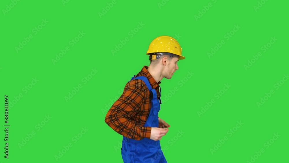Funky dancing by young construction worker in safety hat on a Green ...