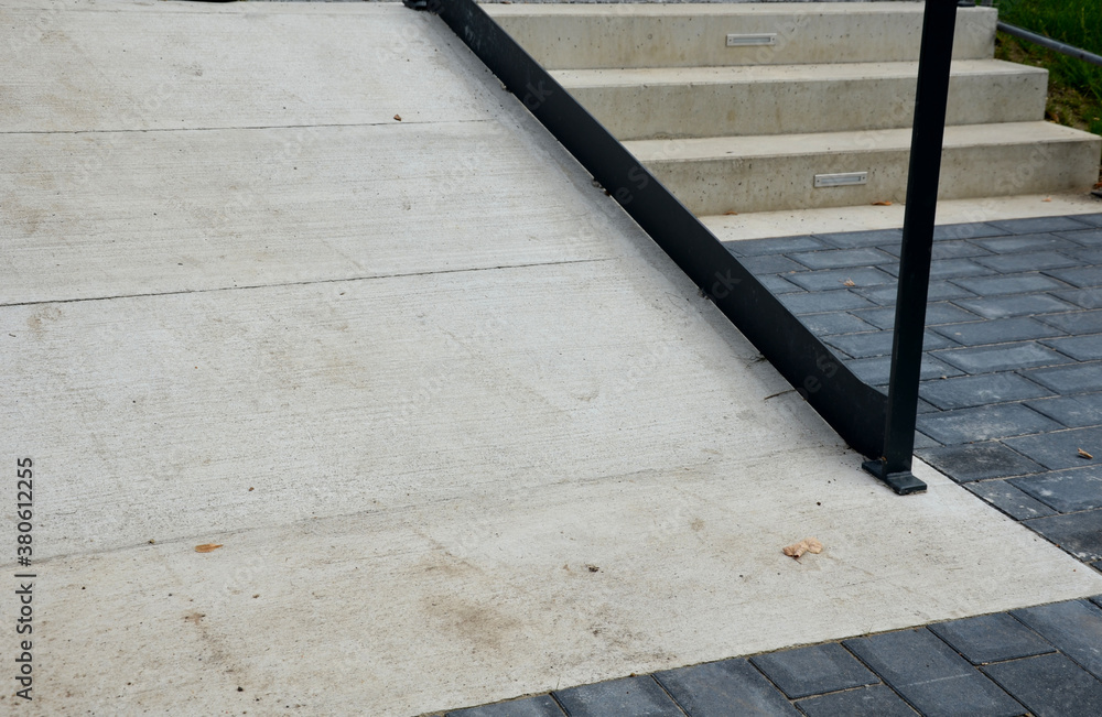 barrier-free ramp next to a concrete staircase in the park with a ...
