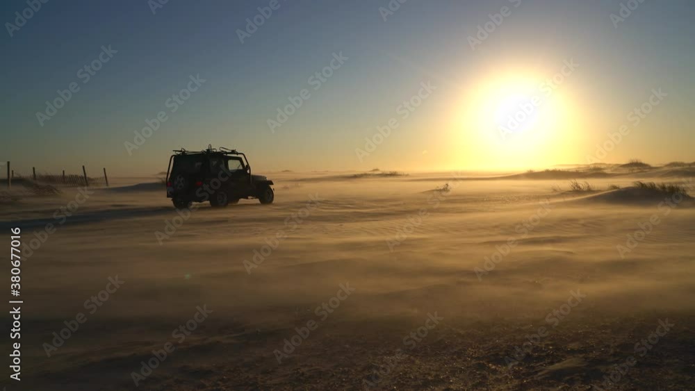Silhouette dune buggy explores the abandoned terrain of the sweltering ...