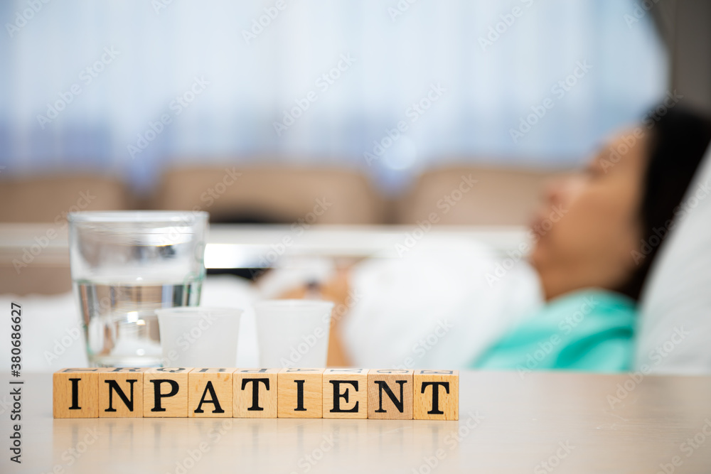 Female patient sleeping in hospital patient room with Inpatient wording ...