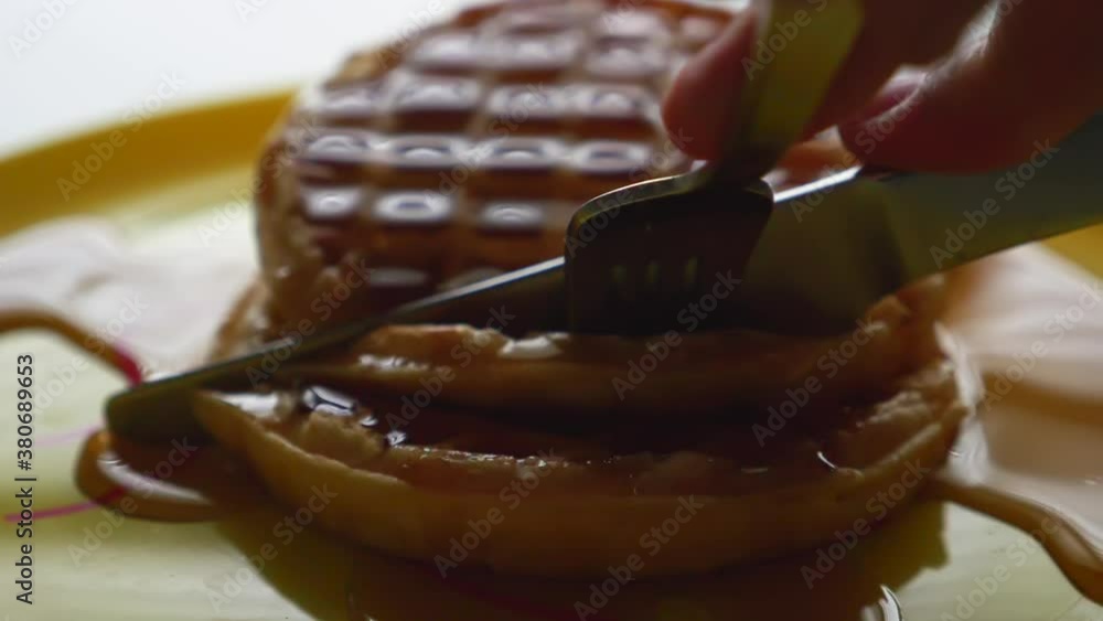 Action of cutting up waffles on a yellow plate. This SLOW MOTION scene ...