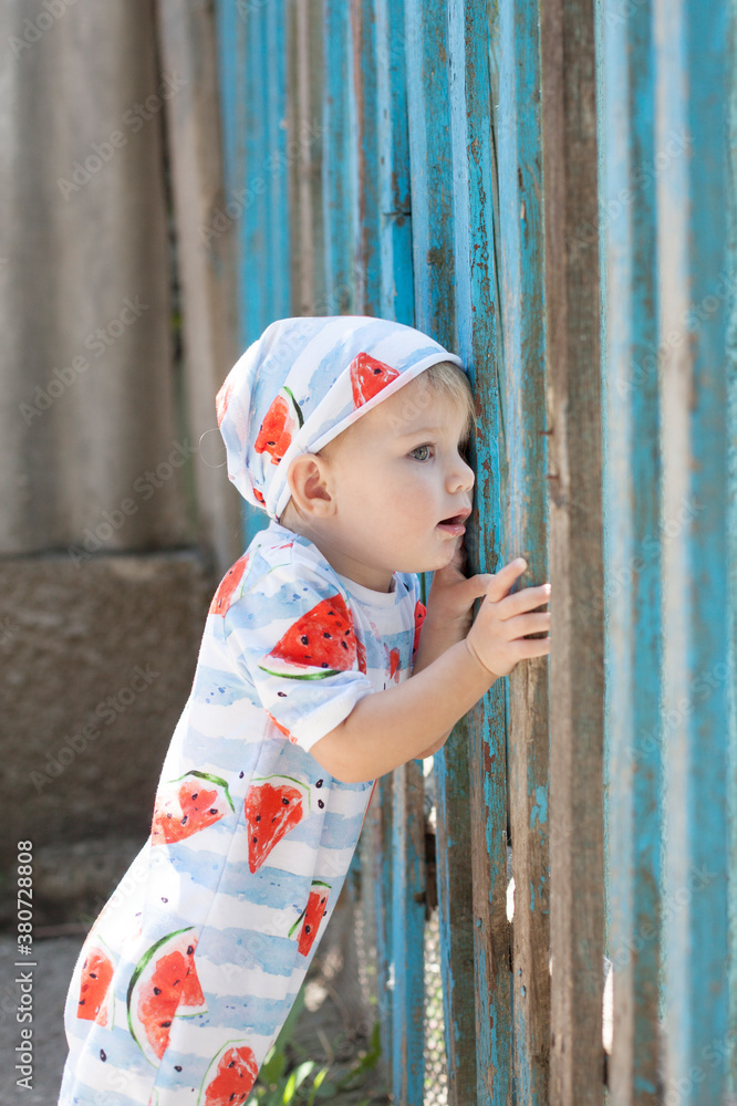 Child peeking over a blue fence Stock Photo | Adobe Stock