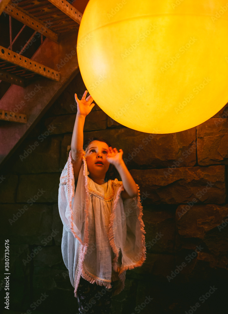 Scene of a kid under the stairs touching a big orange lamp Stock Photo ...