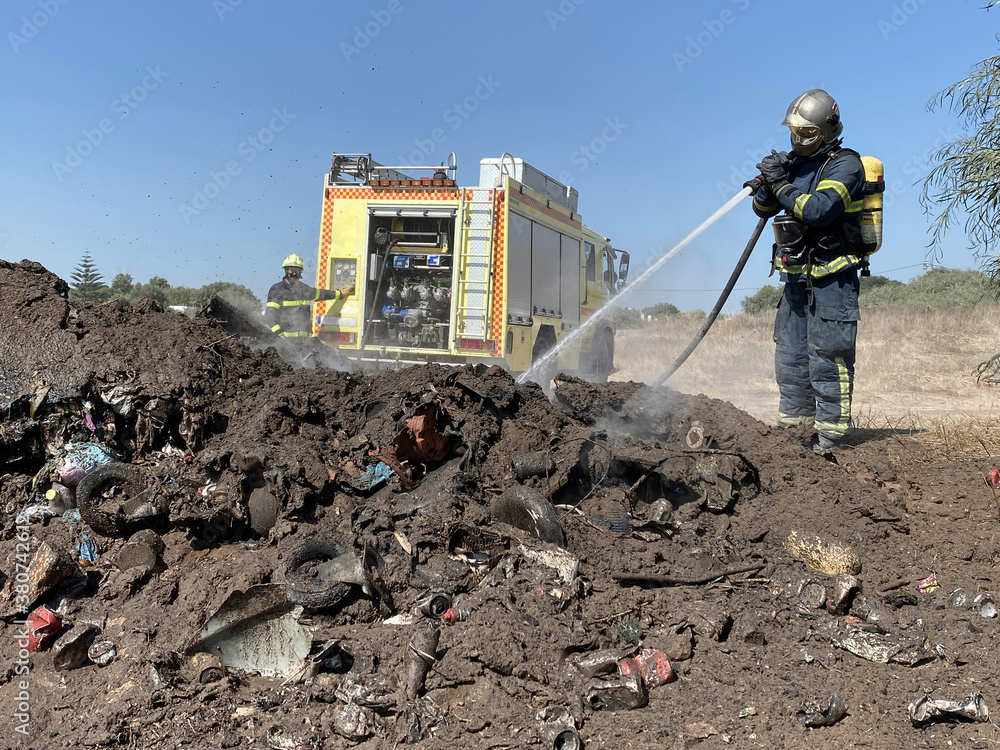 Foto de Brave fireman in protective uniform standing with hose and ...