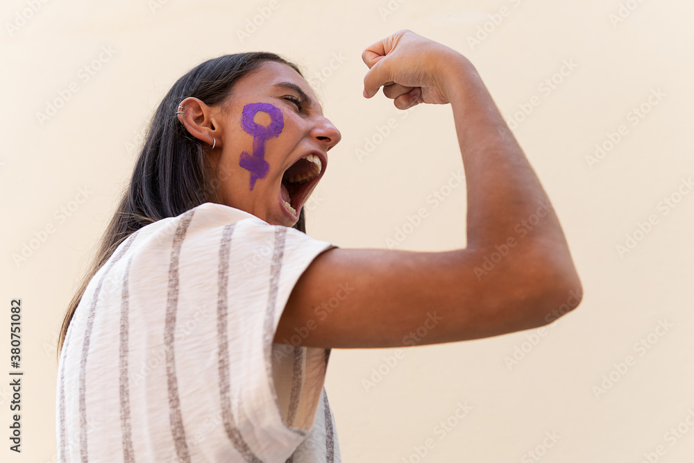 Side view low angle of determined female with gender symbol on face ...
