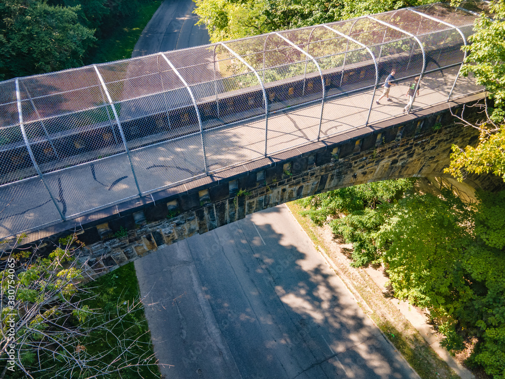Old stone pedestrian bridge in woods with leaves just starting to ...